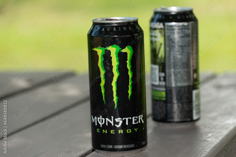 empty cans of Monster Energy drink on an outdoor picnic table in the ...