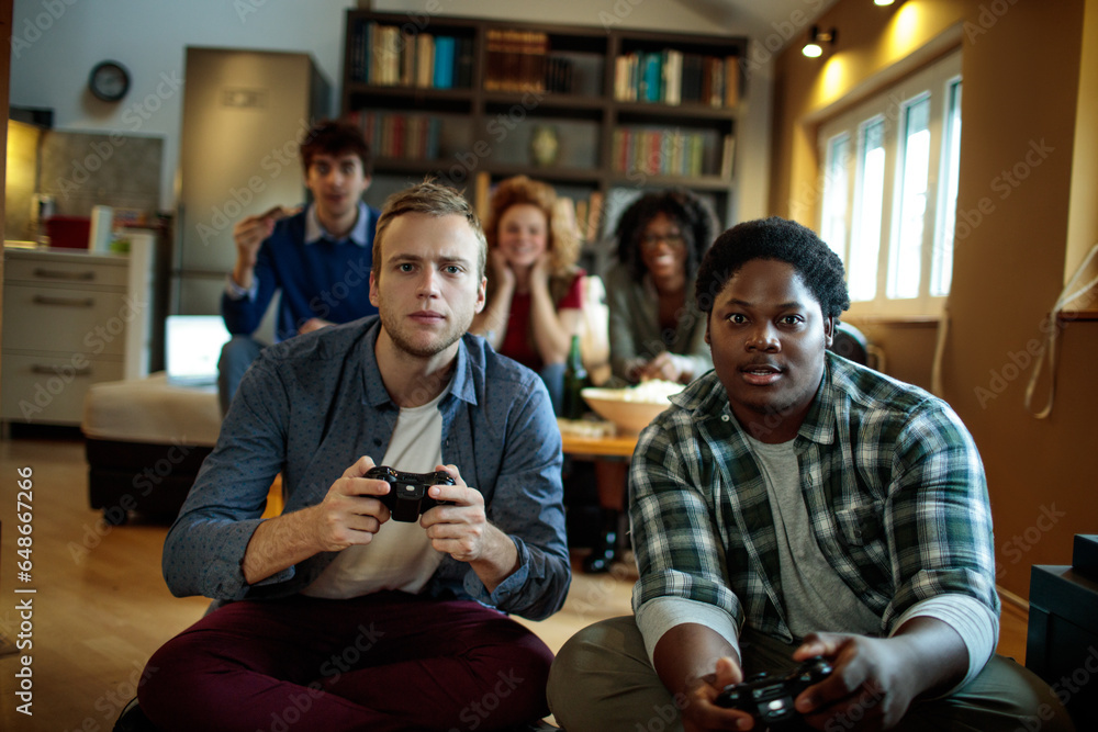 Young and diverse group of friends playing video games on a gaming ...