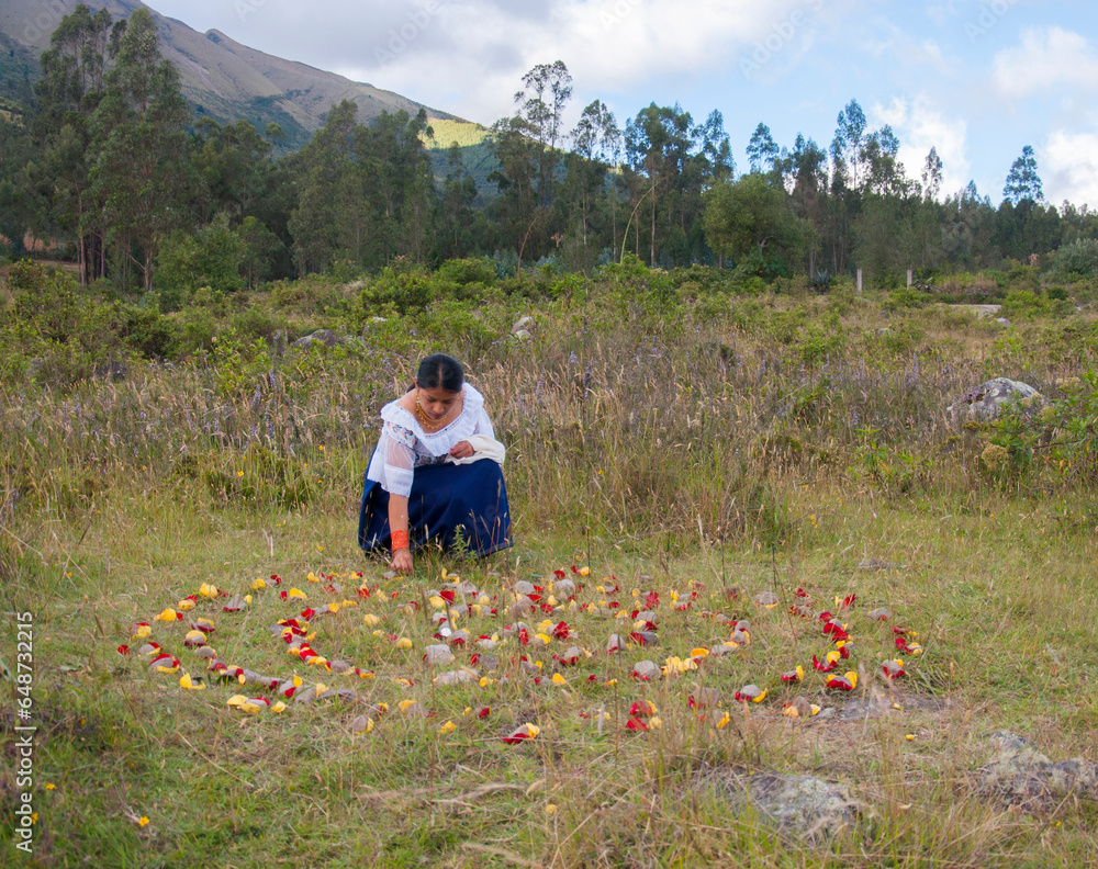 indigenous woman preparing a spiral with stones, yellow rose petals and ...
