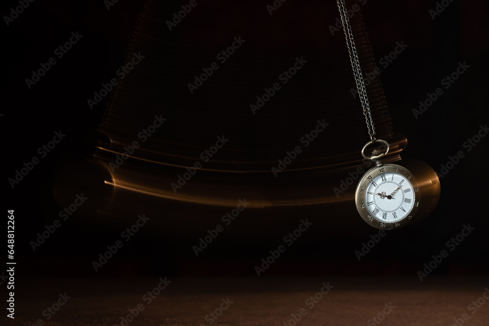 Hypnosis session. Vintage pocket watch with chain swinging over surface ...