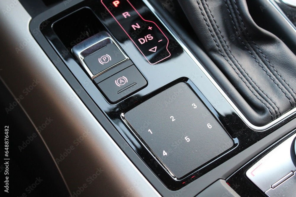 Touchscreen panel on car dashboard. Electronic handbrake button. Gear ...