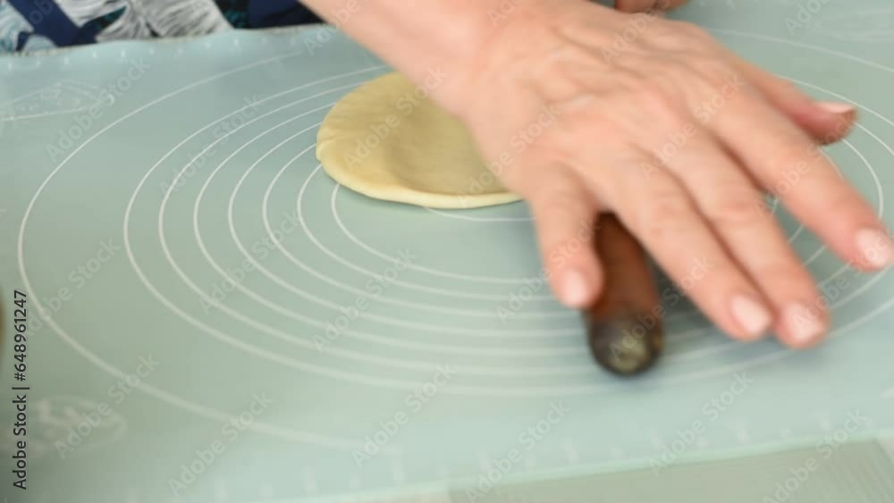 Close-up of a woman's hands using a special tool to make a piece of ...