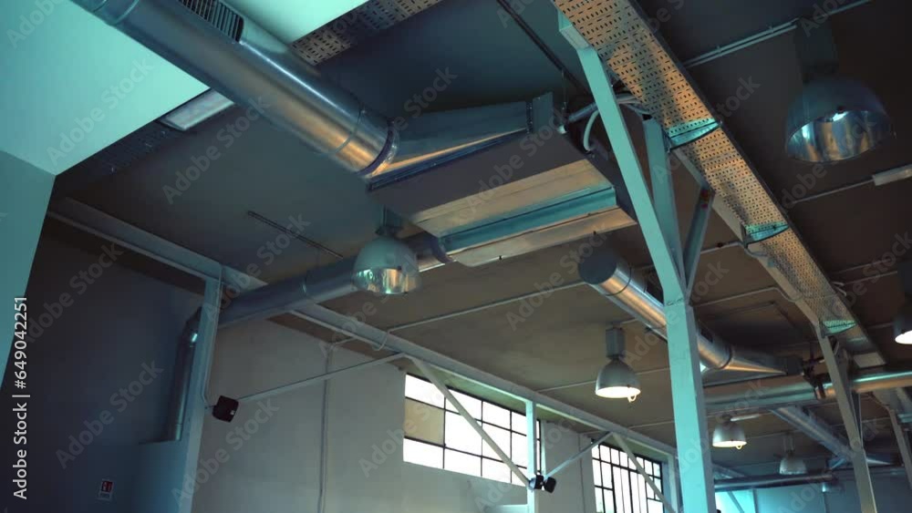 Modern renovated building space with big windows, hanging lamps and ventilation system on the ...