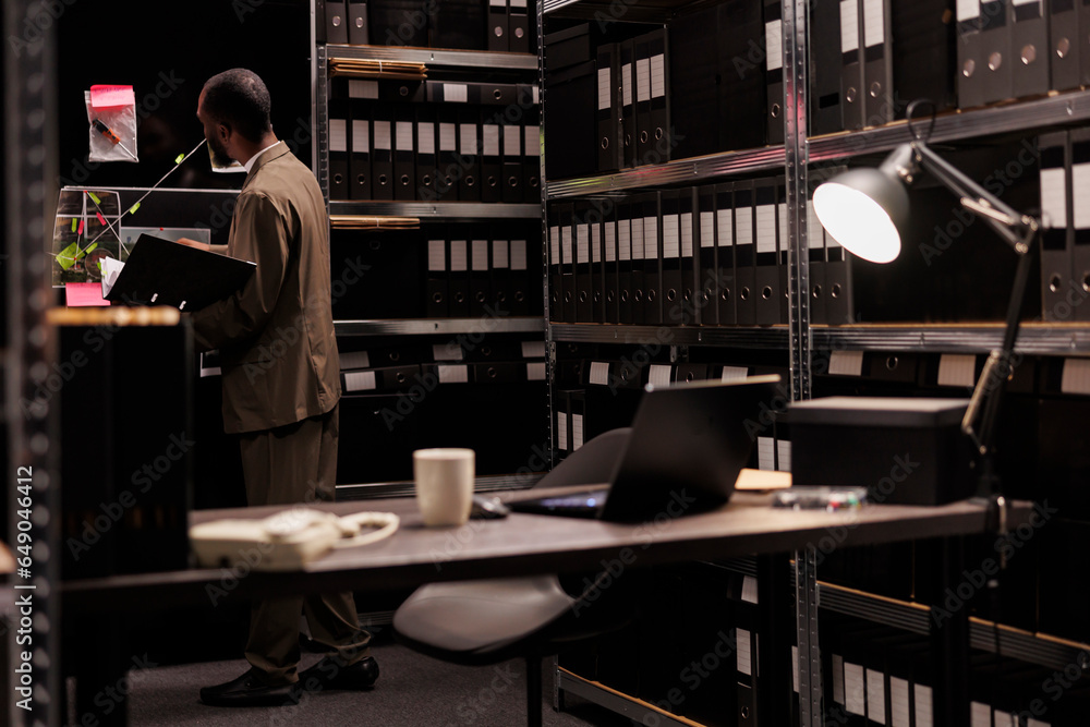 Police investigator standing near detective board analyzing clues ...