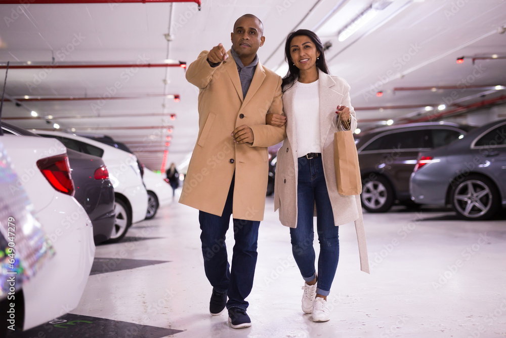 Elegant married couple in an underground parking lot opens car using ...