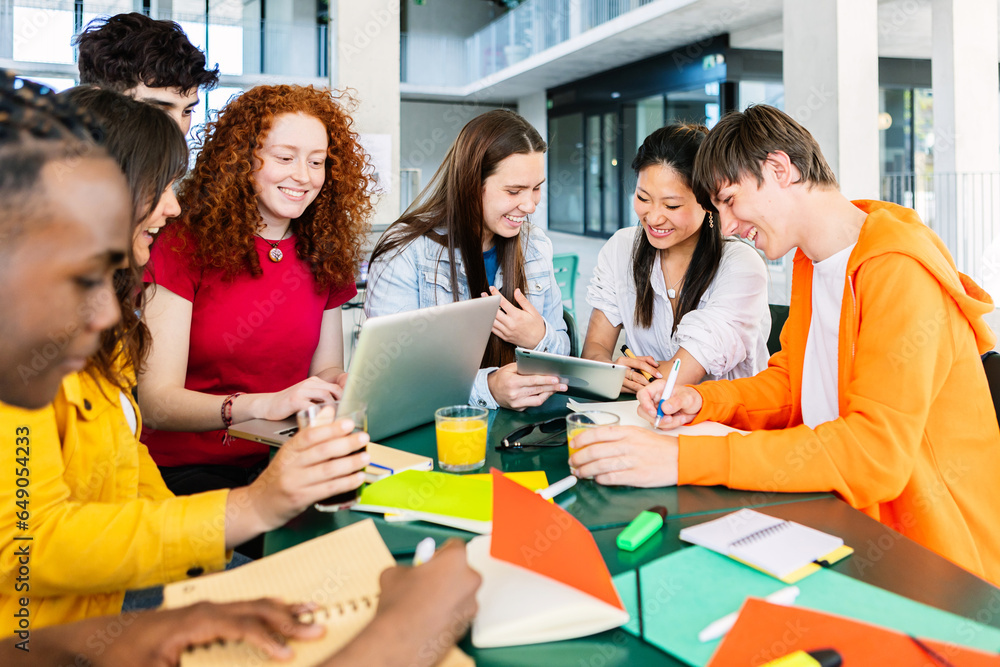 Foto de Young group of high school students studying together at ...