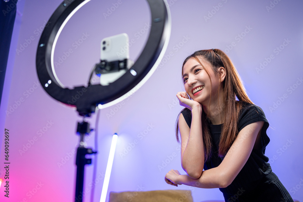 Young trendy influencer asian woman dancing on mobile phone at home in ...