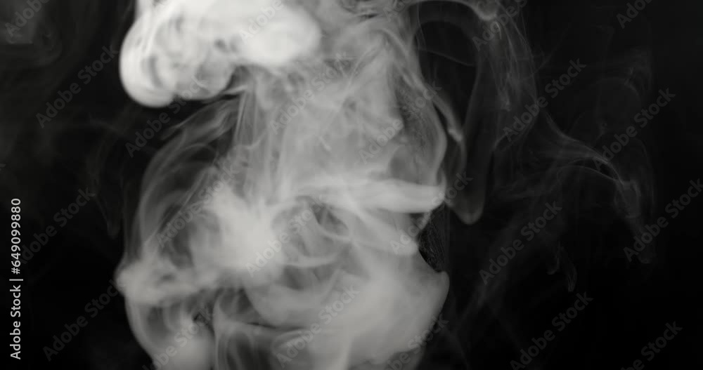 Smoke surrounding mysterious hooded figure with spooky human skull ...