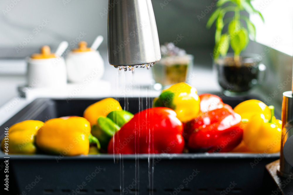Yellow and red pepper are washed in a special tray for vegetables. The ...