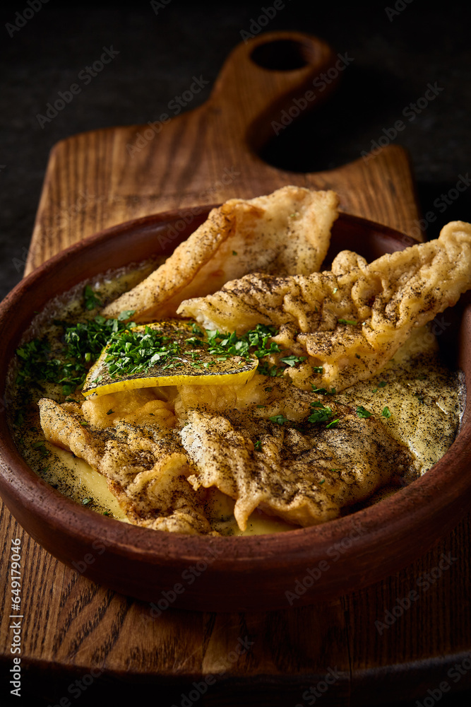 Close-up, vertical side view of the delectable kambala fish, fried to ...