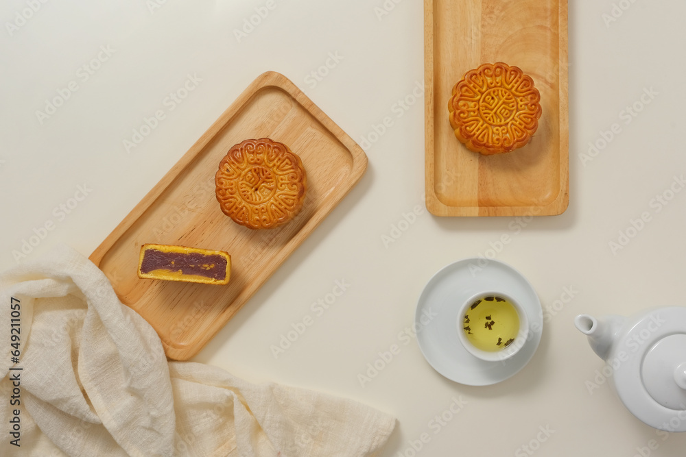 Top view of wooden trays of mooncakes decorated with tea set on white ...