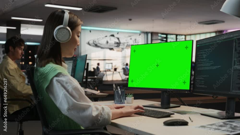 Female Asian Game Programmer Coding On Desktop Computer With Green Screen Chromakey On Display 8830