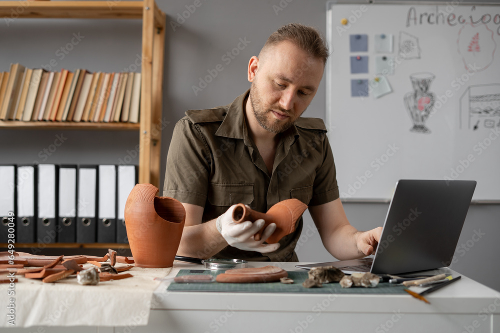 Archaeological digging. Male archaeologist doing research, using laptop ...