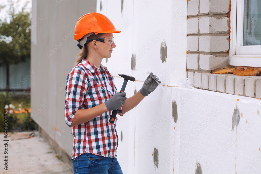 Insulation of the house with polyfoam. The worker is checking with the ...