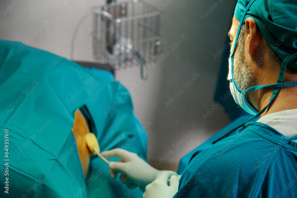 Surgical doctor cleaning with anti septic in back of patient preparing ...