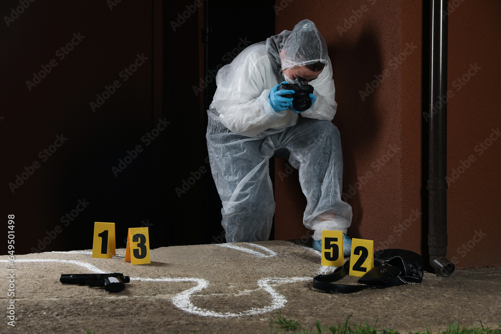 Criminologist in protective suit working at crime scene outdoors. Space for text Stock Photo ...