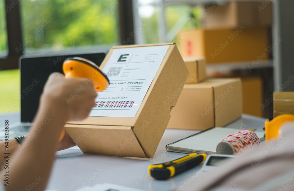 online small business owner scans a barcode-labeled parcel with a ...