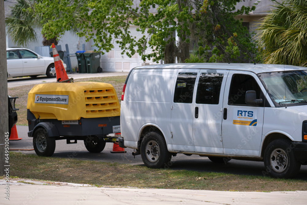 Utility van with yellow compressor trailer with jackhammer machine on ...