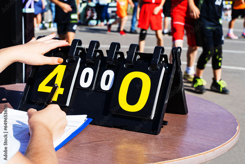 Scoreboard at a street sporting event. The referee turns over the ...