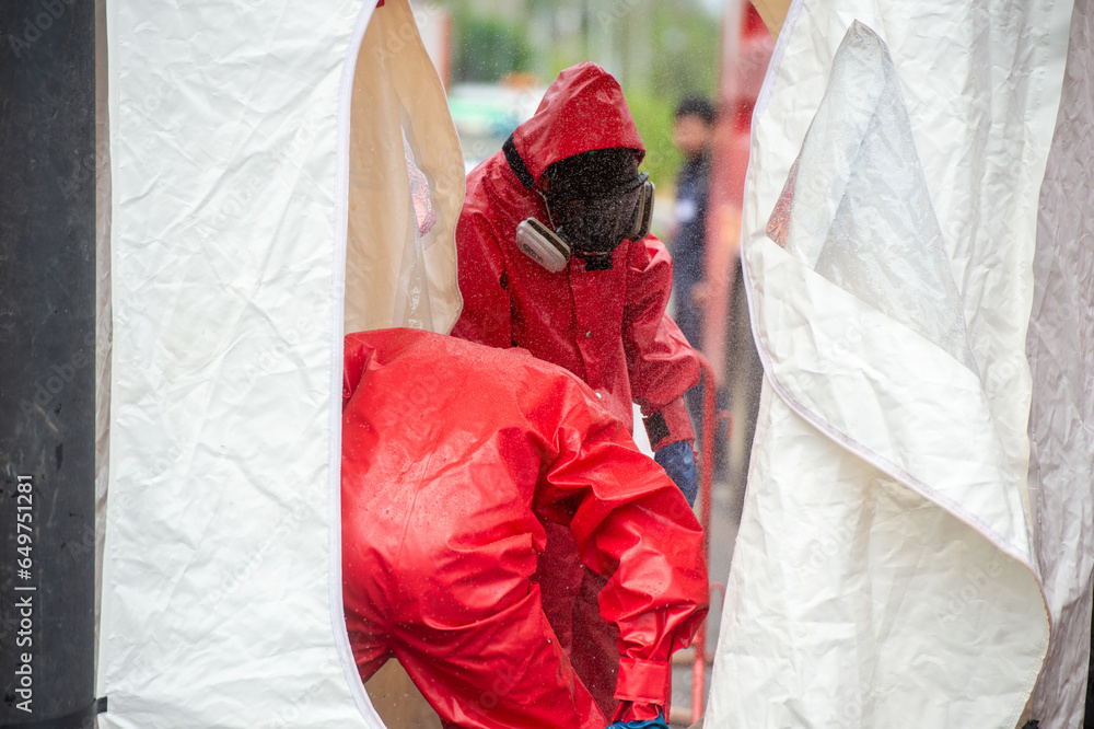 Rescuers wearing red hazmat suits assembled a Inflatable sterilization ...