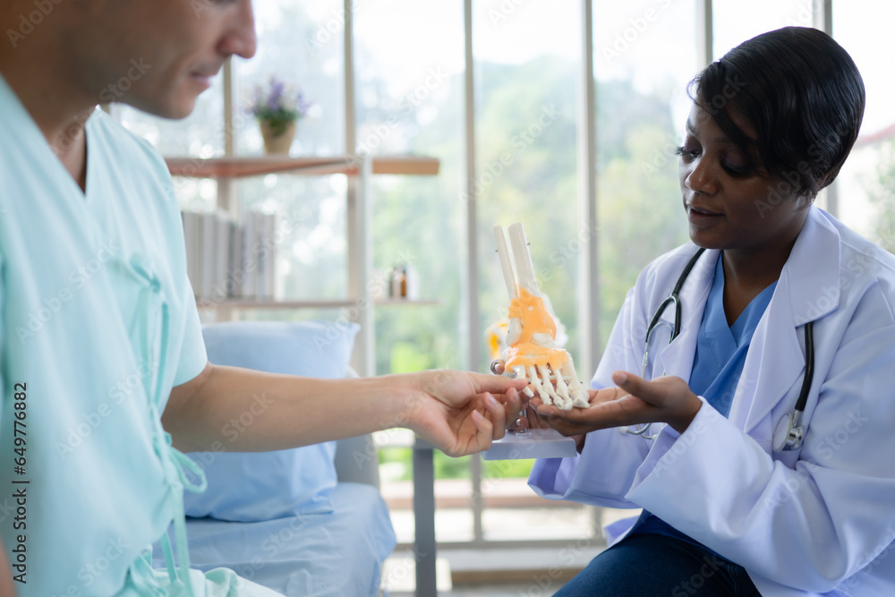 Photo & Art Print Doctor showing model of foot bones to patient in ...