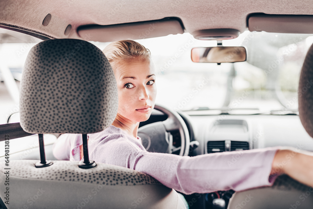 Beautiful young lady looking back through the rear window from the ...