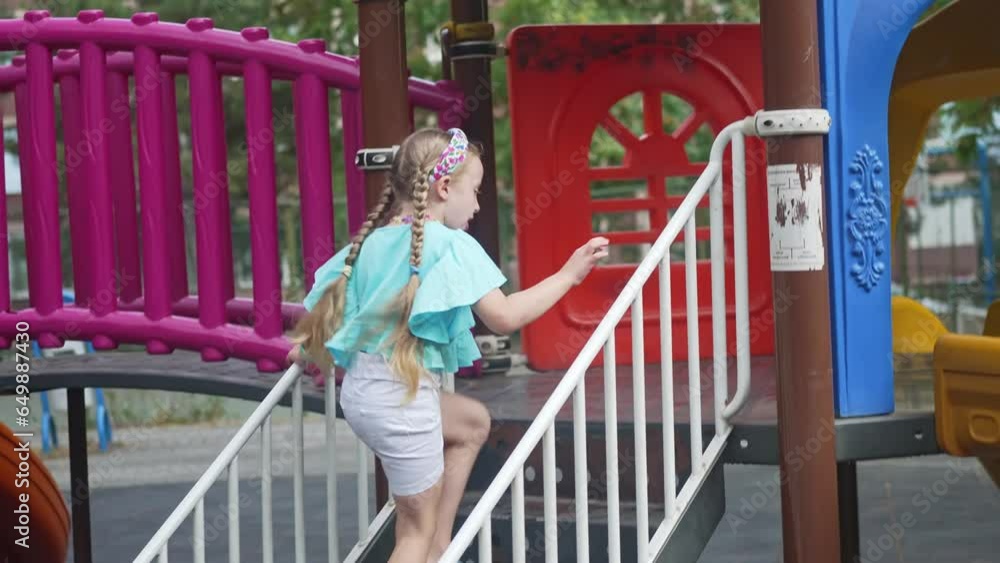 Pretty little girl goes upstairs and slides in maze on children ...