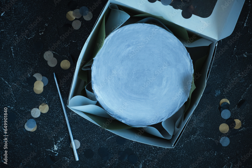 Small bento cake in a white gift box on the dark moody blue background ...