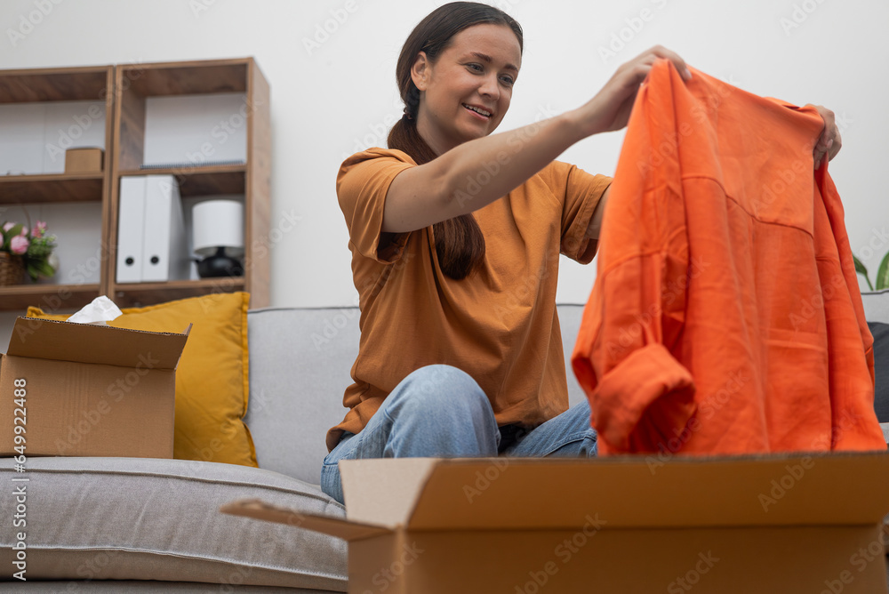 A shopaholic woman gleefully unpack latest delivered parcel, affirming ...
