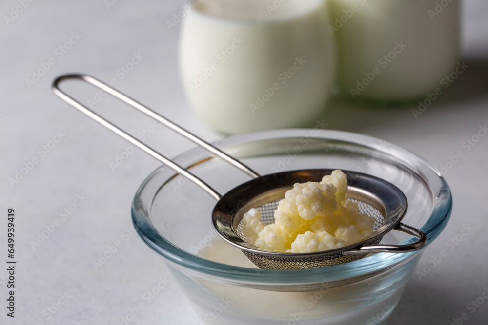 Kefir fermented milk drink with kefir grains. Homemade kefir stands in ...