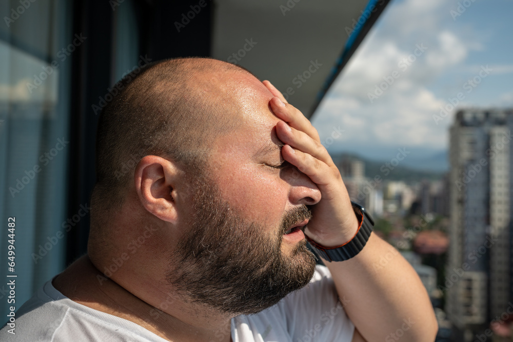 Portrait overweight man has headache touching forehead in heat summer ...