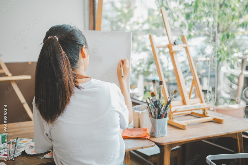 Art student drawing with watercolor painting on canvas doing some art ...