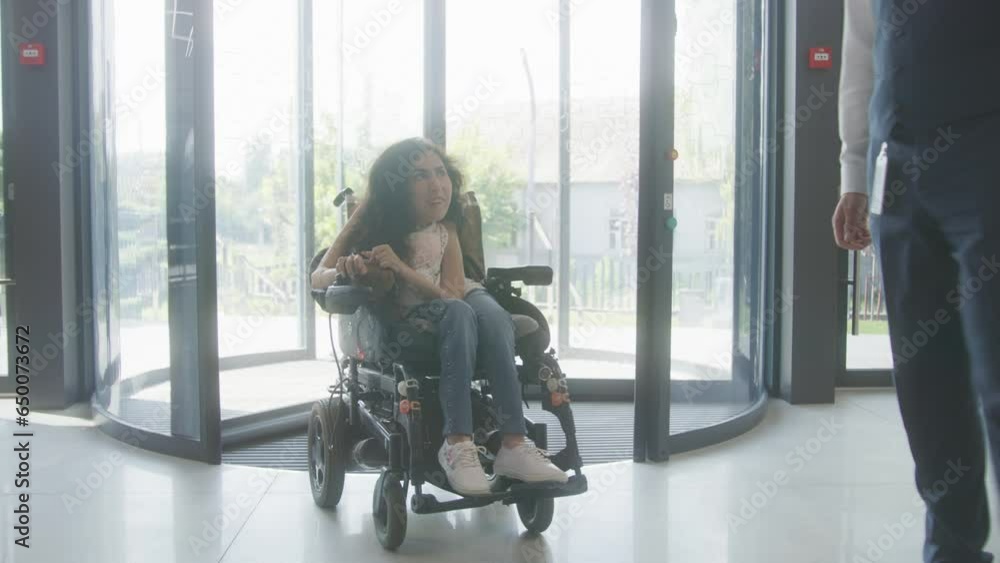 Woman with physical disability rides in clinic entrance on electric ...