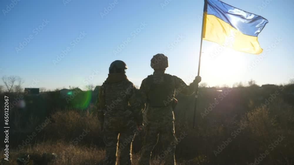 Female and male soldier of ukrainian army standing at peak of hill with ...