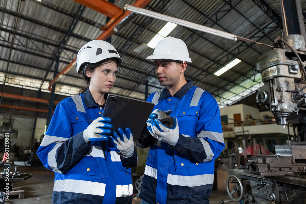 Team workers wearing uniform safety and hardhat using tablet working at ...