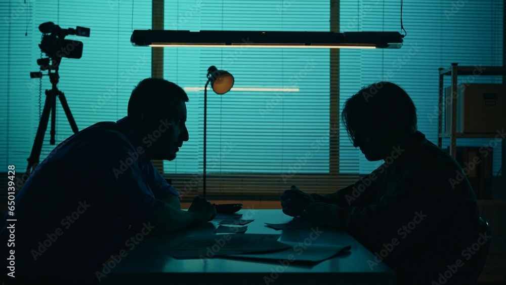 Medium silhouette shot of an offender, perpetrator or prisoner sitting ...