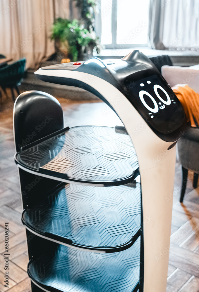 Robot waiter serve food at modern restaurant table.Offering innovation ...