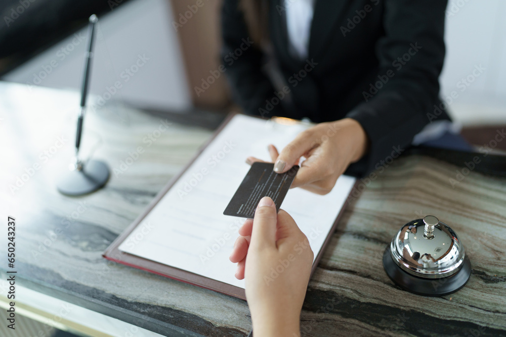 Hotel receptionist in uniforms Concierge giving the key doing check-in ...