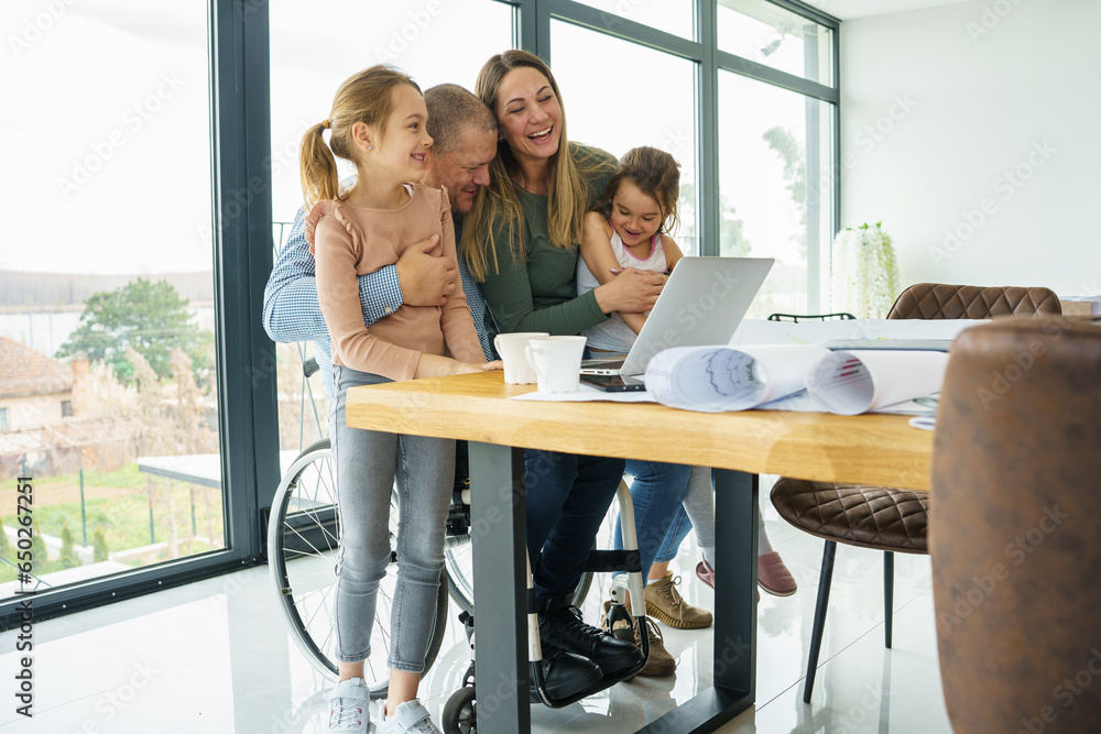A physically challenged father works from home, supported by his family ...