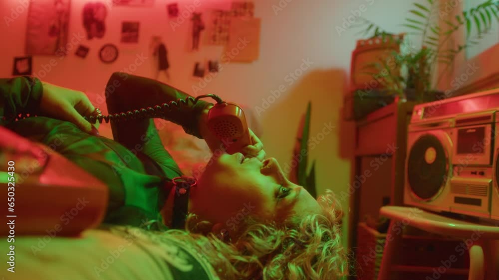 Young girl lying down on bed in 90s aesthetic bedroom with neon light ...