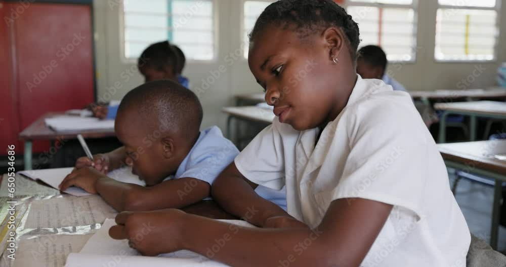 Close-up. Black African school children drawing at a desk in a ...