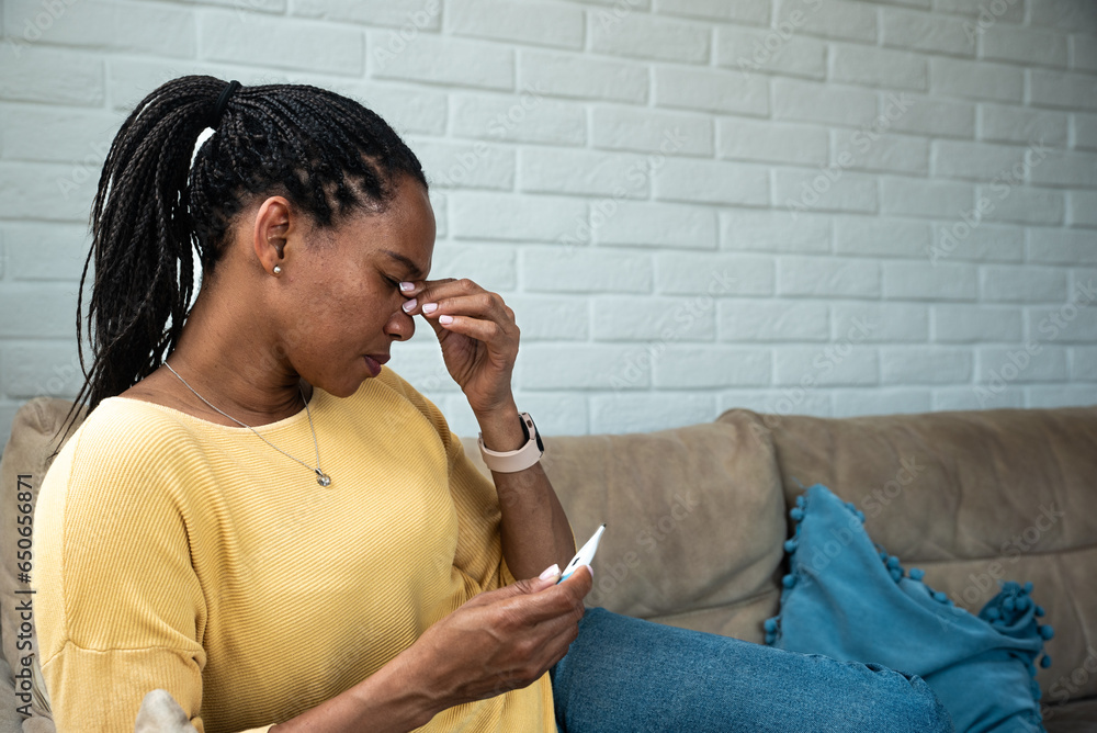 Sick woman lying in bed with high fever. African American female ...