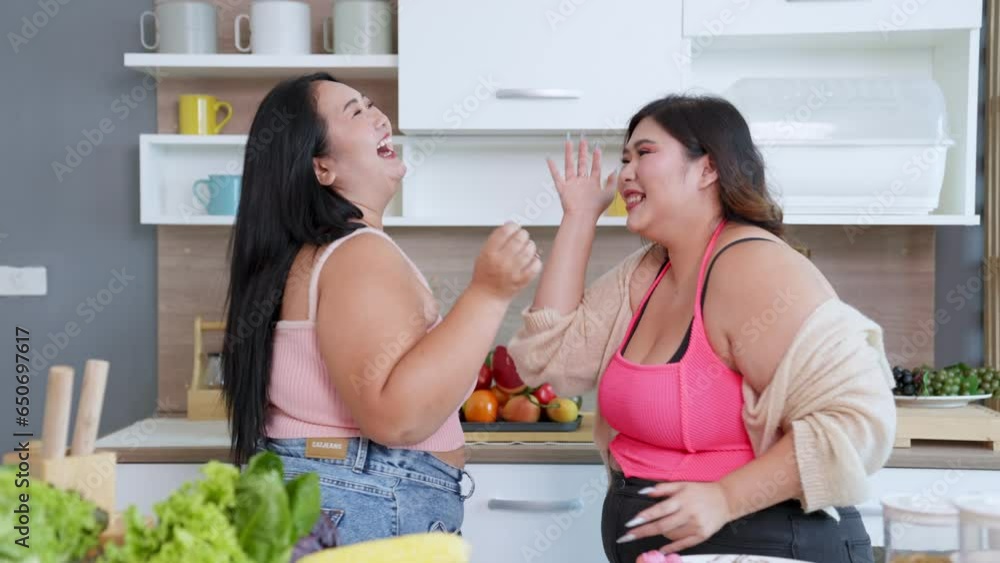 Happy plus size asian women dancing in the kitchen at home. having fun ...