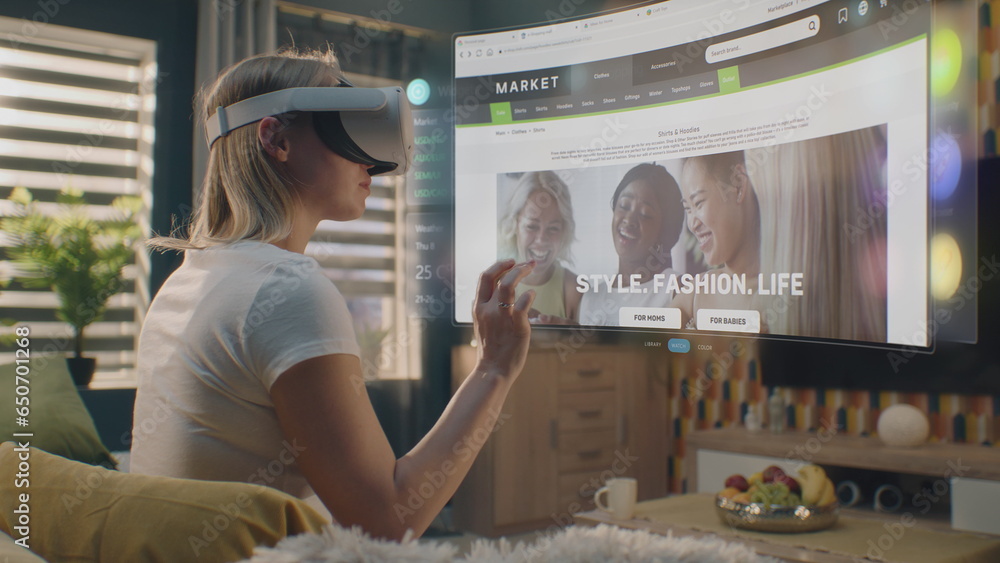 Woman in VR headset chooses clothes in online store chilling at home ...