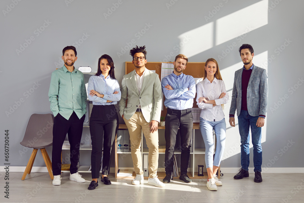 Happy confident business team standing in line against wall. Group of ...