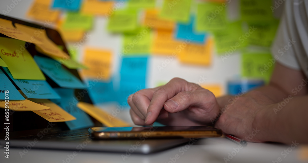 blurred colorful post note background, man using pencil and computer ...