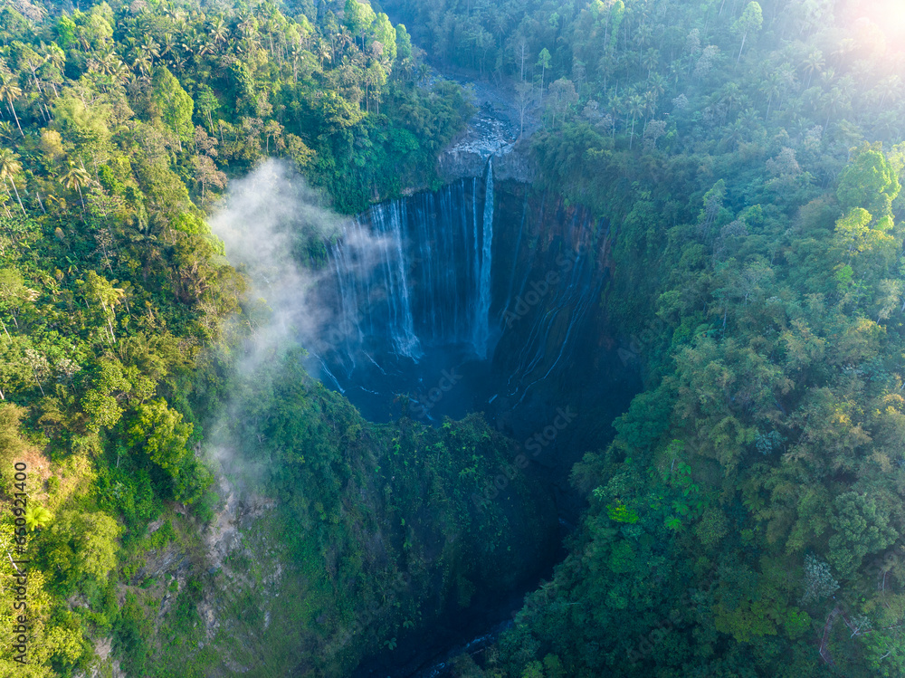 Top view of Tumpak Sevu Waterfall in the morning with sunlight. And ...