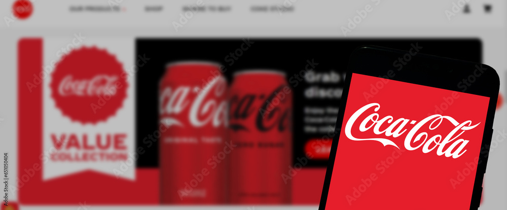 Coca-Cola logo on smartphone screen with defocused website on the ...