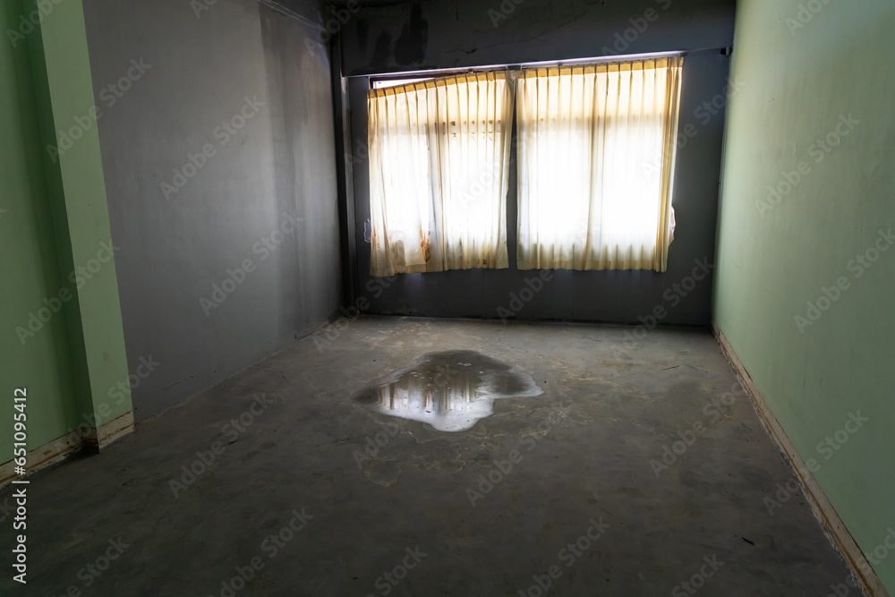 Close-up of spilled water leak on the floor of building. Wet floor from ...