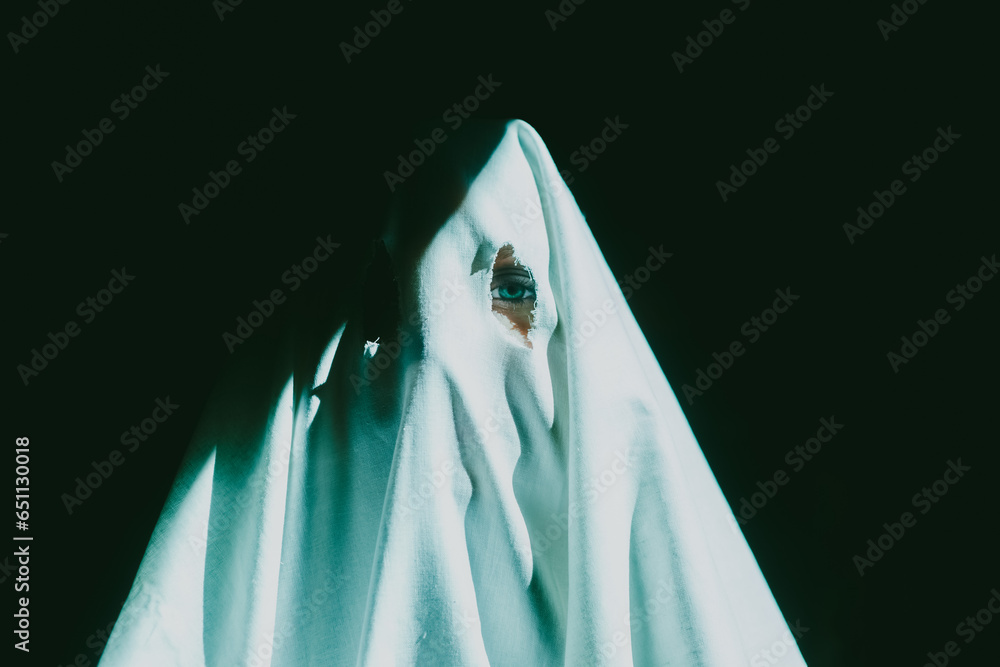 The photo depicts a woman dressed in a white ghostly outfit with eye ...